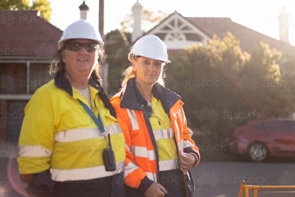 Image of Two women road workers wearing white helmet with high vis in ...