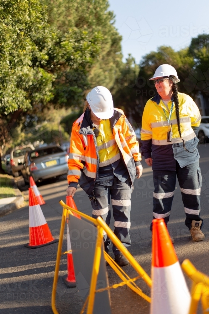 Image of Two women road workers with white helmet orange and yellow ...