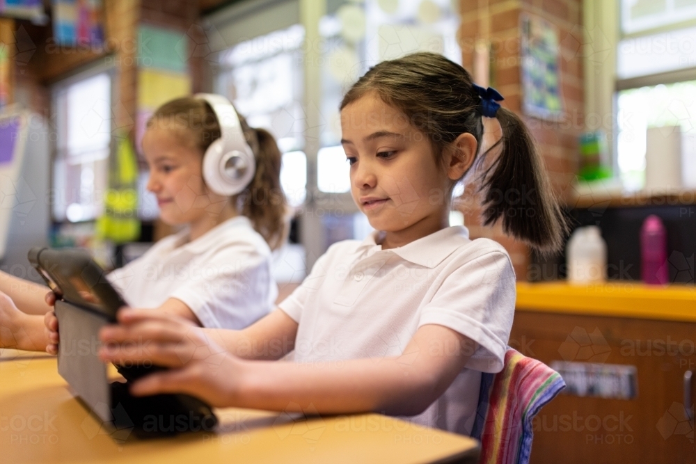 Image of Two Young Schoolgirls Learning on iPads - Austockphoto