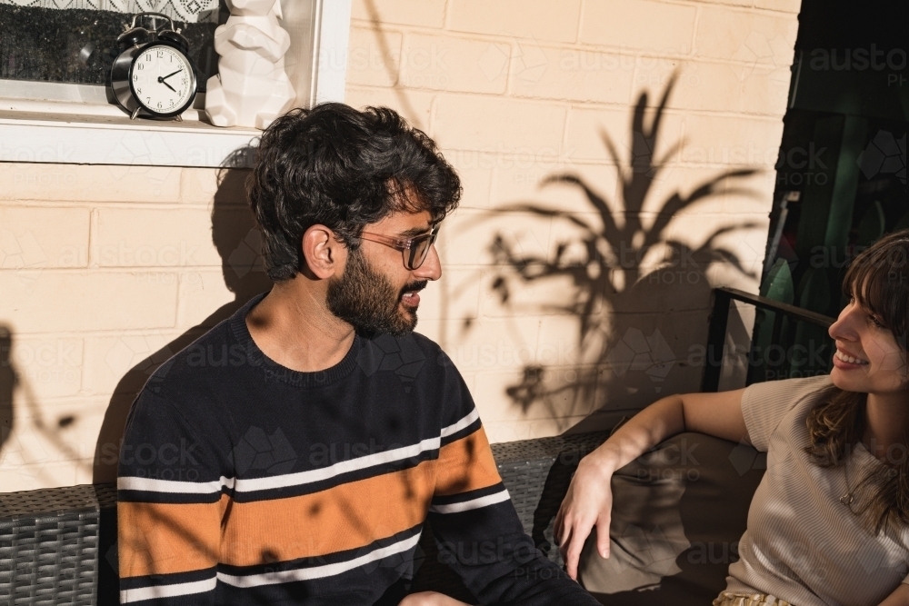 Image of UGC style, couple sitting outside in the sun on their house ...