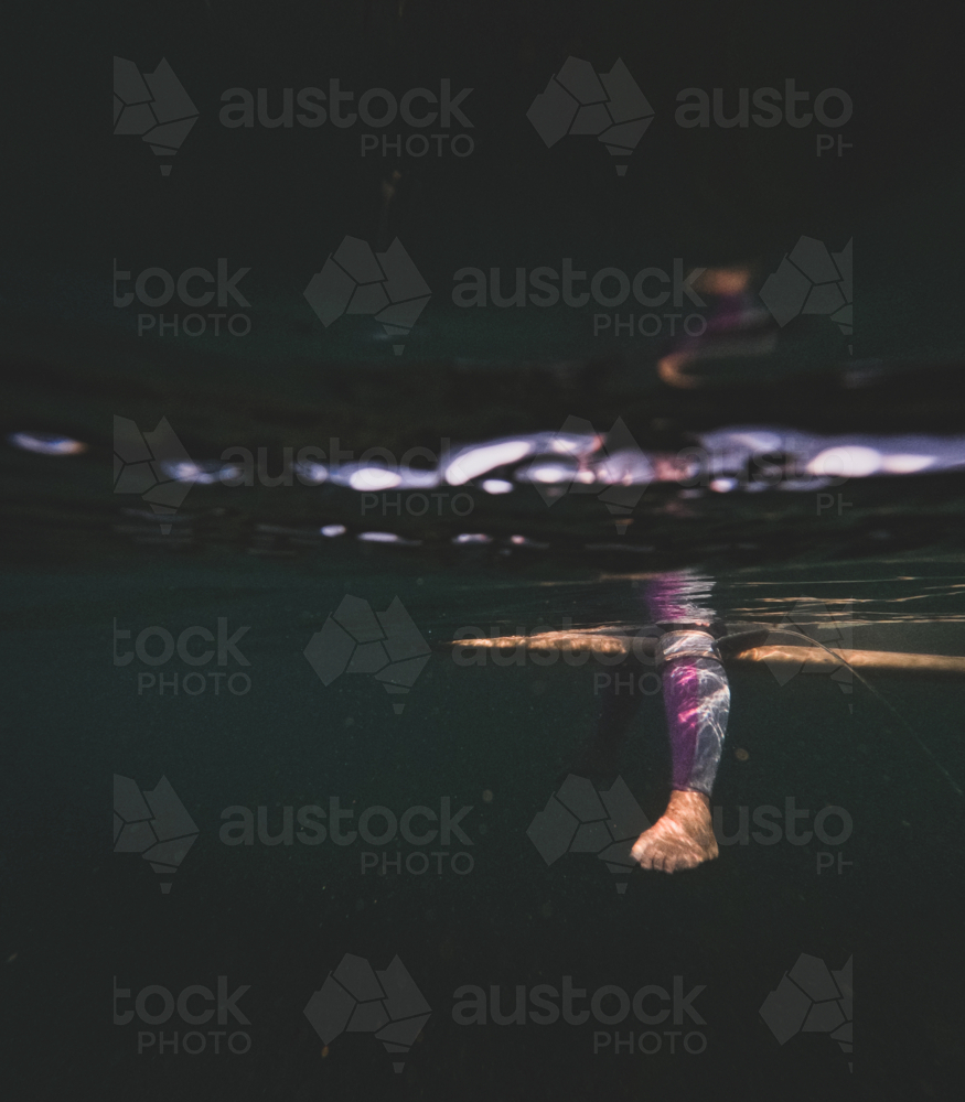 Image of Underwater of Surfboard floating on surface with leg in ...