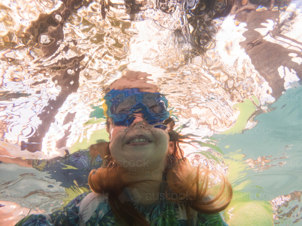 Image of Underwater view of toddler putting mouth in water during ...