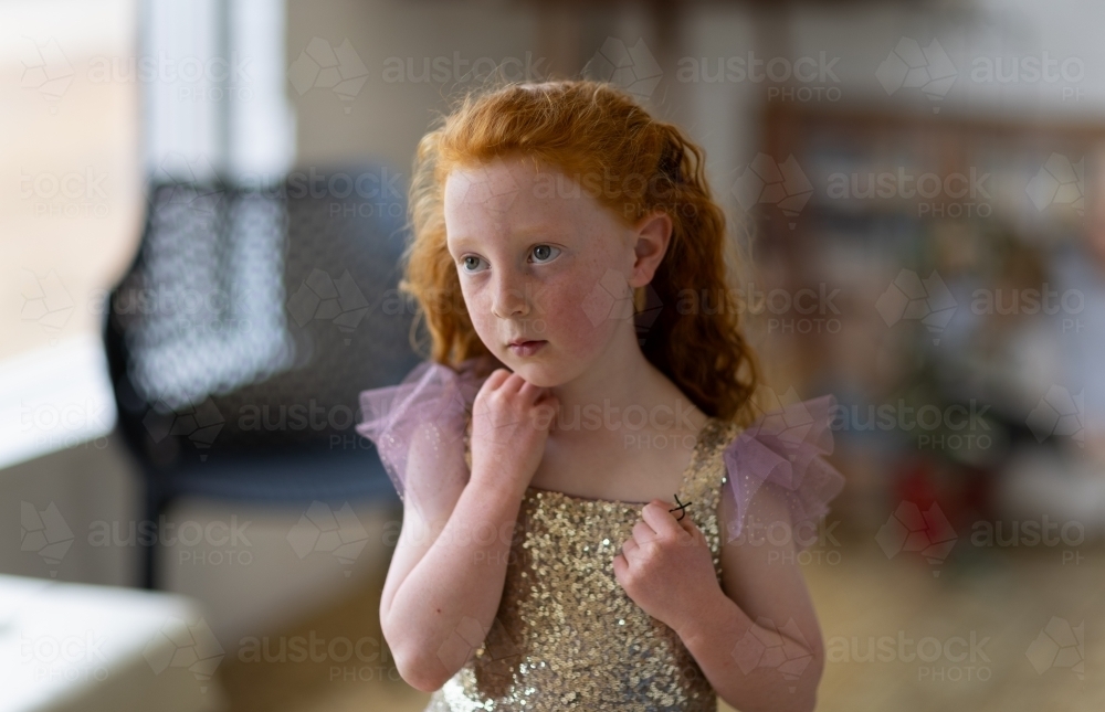Image of upper body view of child indoors looking up meekly - Austockphoto
