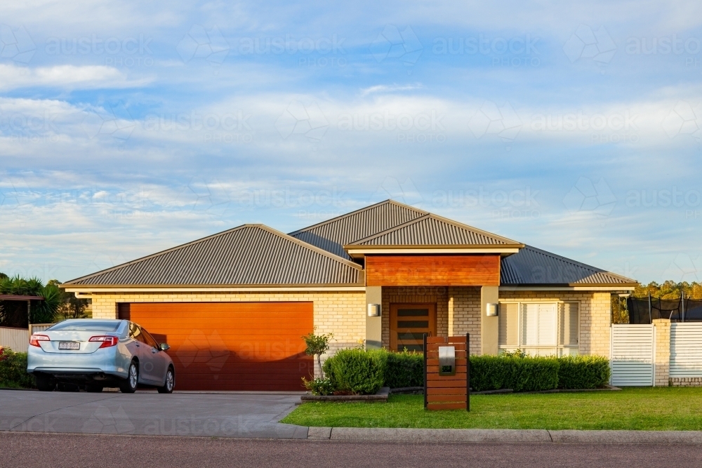 Image of Urban house with car parked in driveway in the evening ...