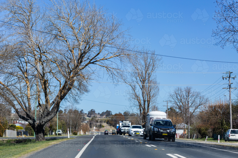 Image of Vehicle pulling horse float down road in late winter through ...