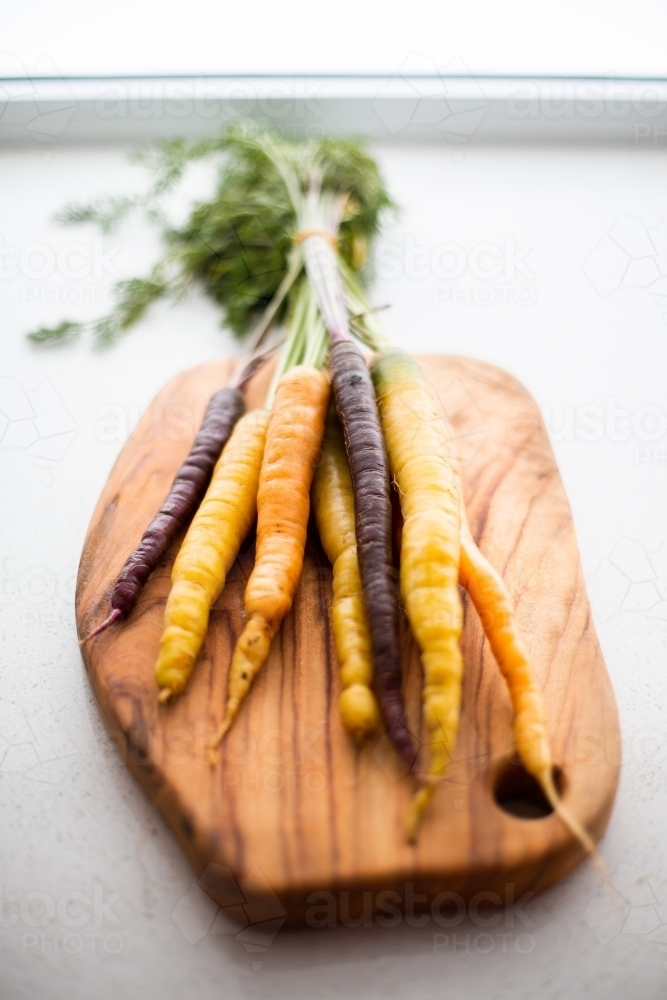 Image of vertical photo of a bunch of rainbow carrots - Austockphoto