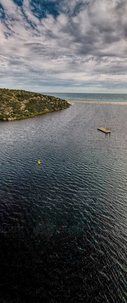 Image of vertical photo of the ocean with wooden raft and an island ...