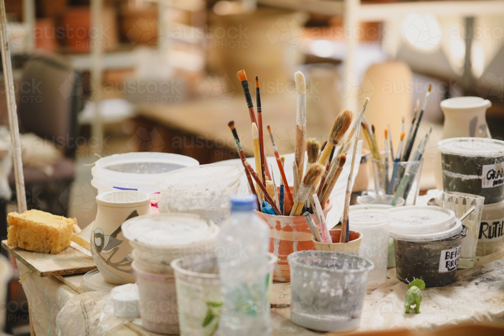 Image of Vibrant artist's studio with paintbrushes, containers, and ...