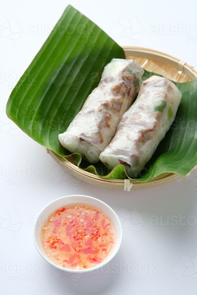 Image of Vietnamese spring rolls on leaf in bamboo bowl with dipping ...
