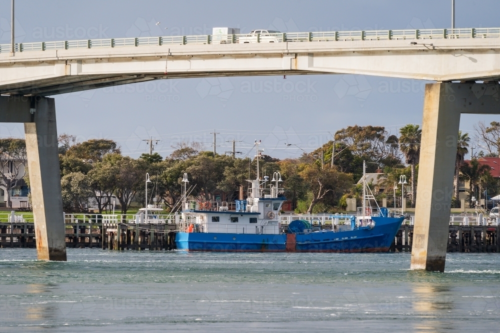 Image of View between bridge pylons with a fishing boat anchored ...