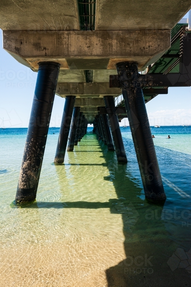 Image of View between pylons under a jetty to the horizon with clear ...