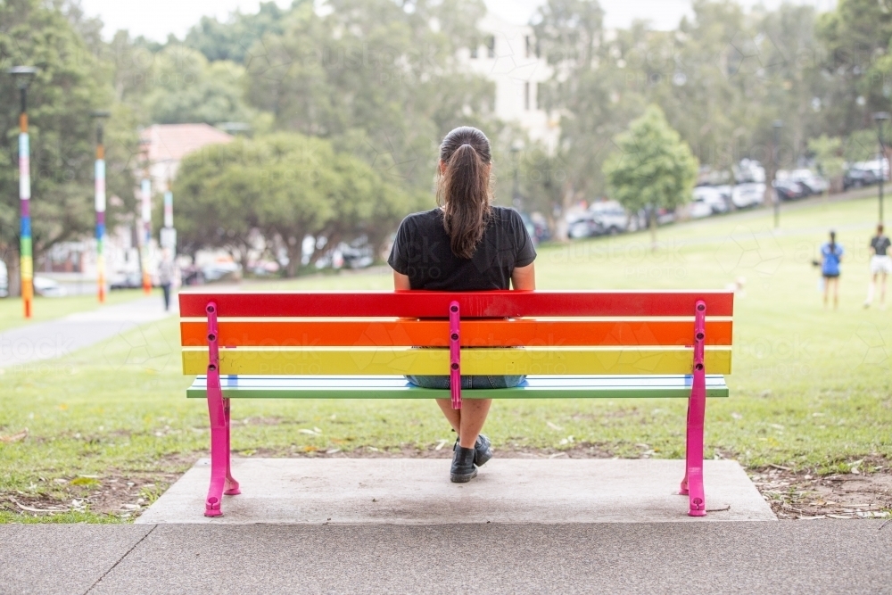 Image of View of woman sitting at a park bench looking out from behind ...