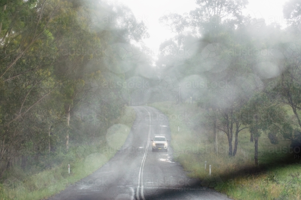 Image of View through car windscreen of heavy rainfall and car driving ...