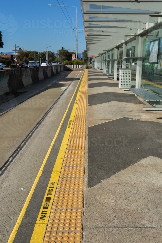 Image of Wait behind the yellow line at tram station stop - Austockphoto