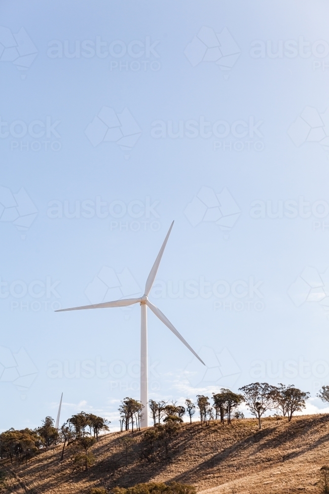 Image of Warm light on bright wind turbine generator on ridgeline in ...