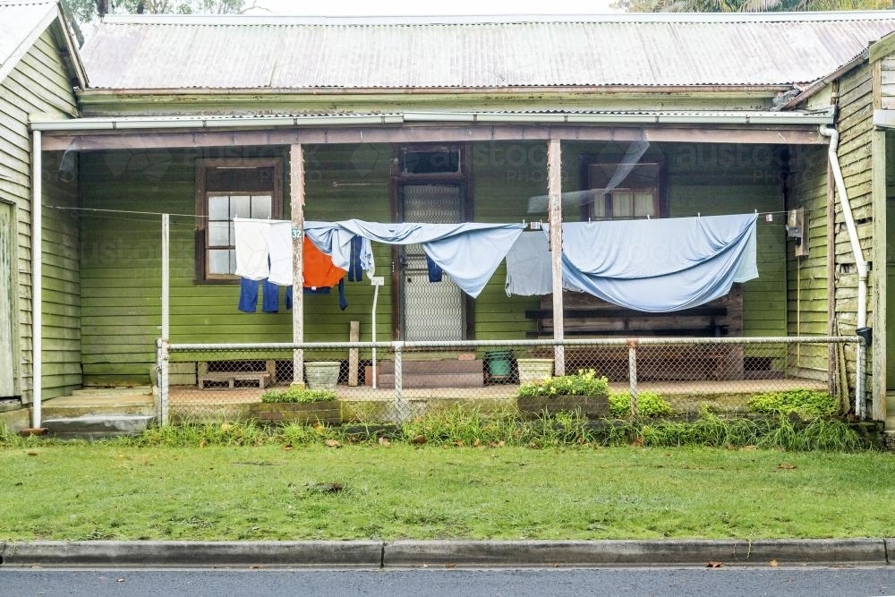 Image of Washing hanging on a clothes line under the back verandah of a ...
