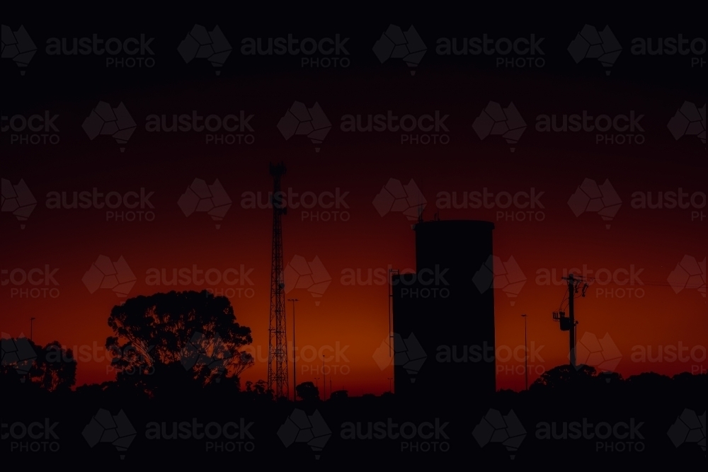 Image of Water and telecommunications towers silhouette at sunset - Austockphoto