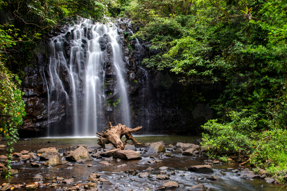 Image of Water cascades over the dark rock face at Ellinjaa Falls ...