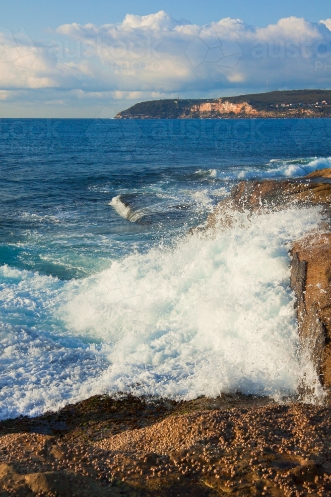 Image of Waves crashing into rocky cliffs - Austockphoto
