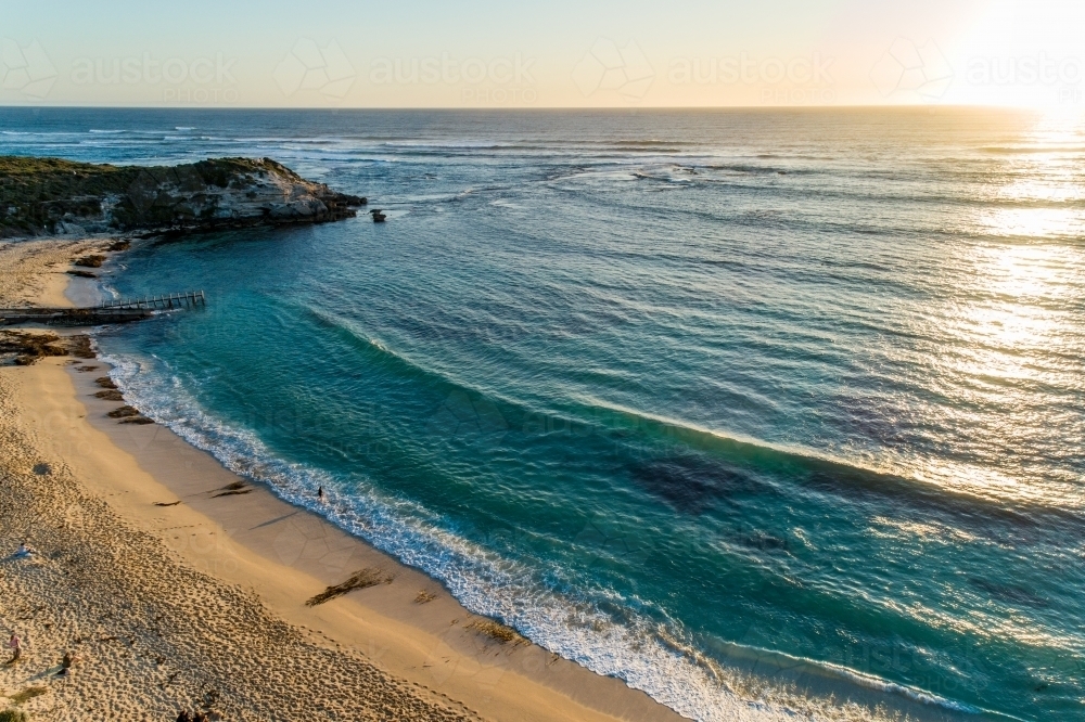 Image of Waves wrapping around a headland in late afternoon light ...