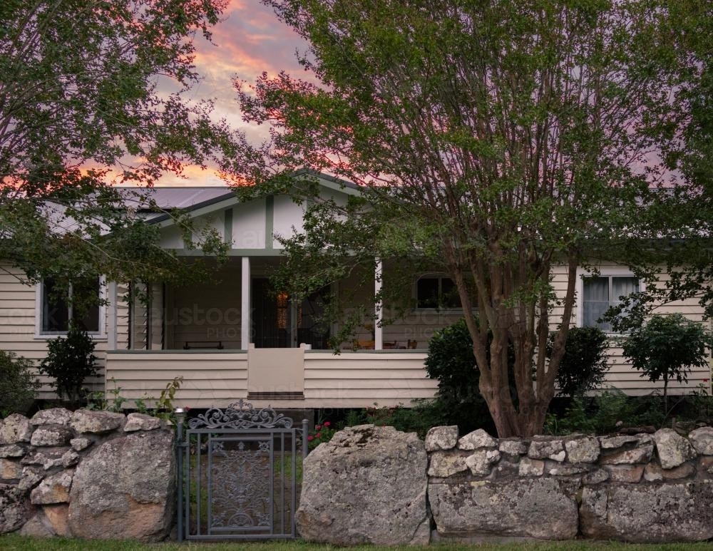 Image of Weatherboard farm house with stone wall and iron gate ...