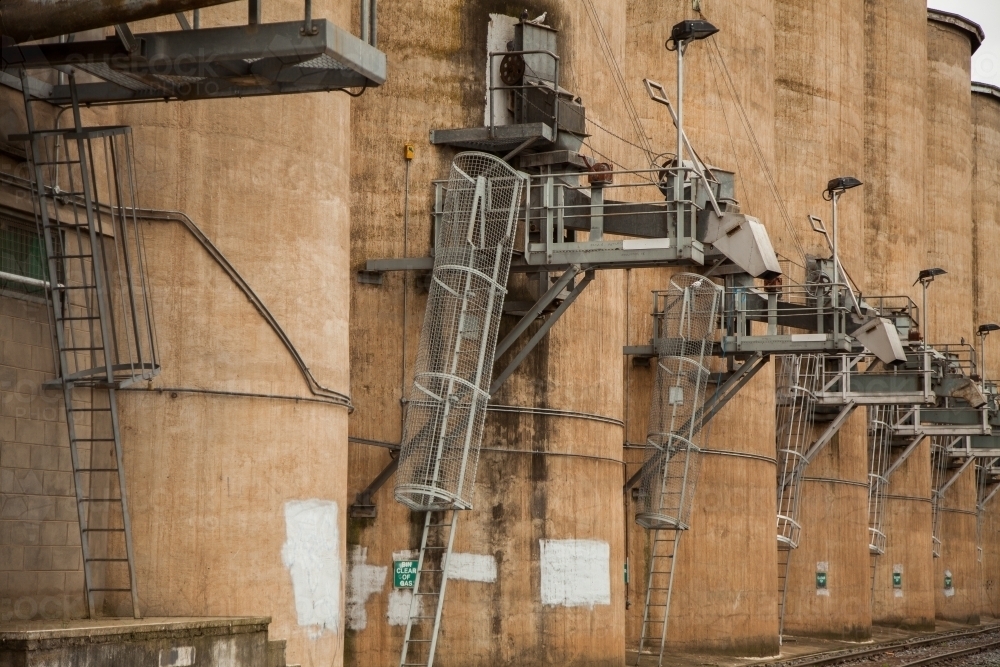 Image of Wheat silo infrastructure beside a train line on an overcast ...