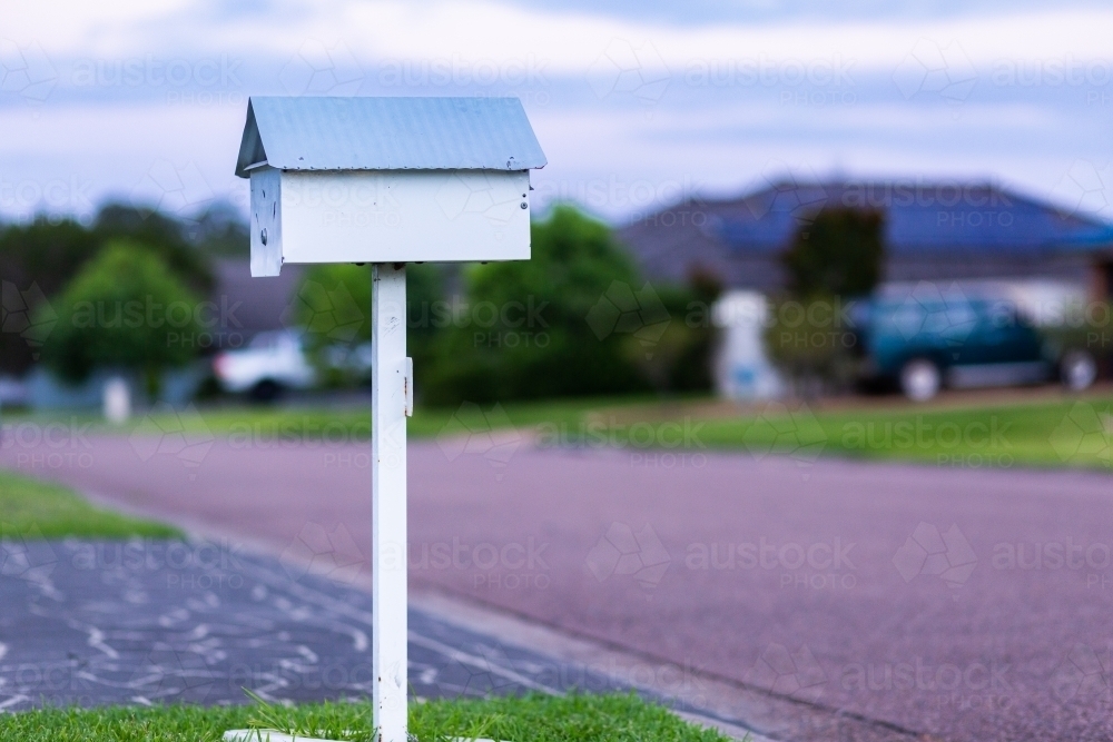 Image of White and blue mailbox beside driveway of house in suburban ...