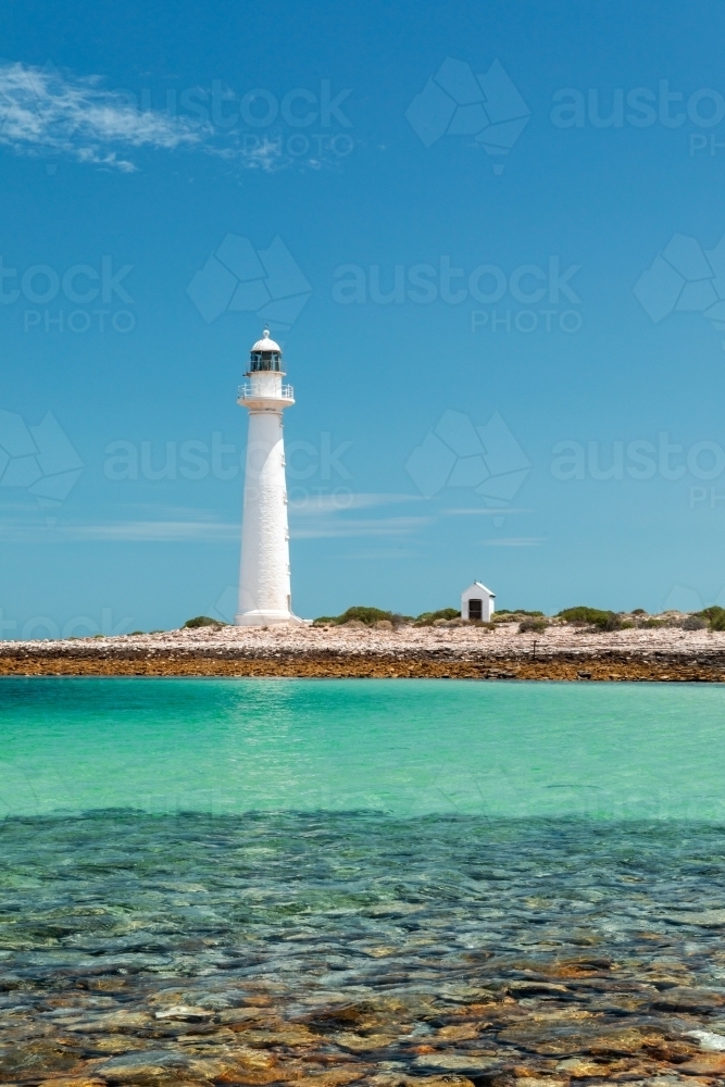 Image of white lighthouse with blue sky and turquoise shallow water ...