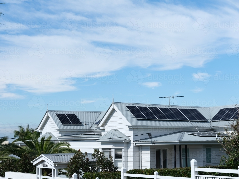 Image of White single-story house with solar panels on the roof ...