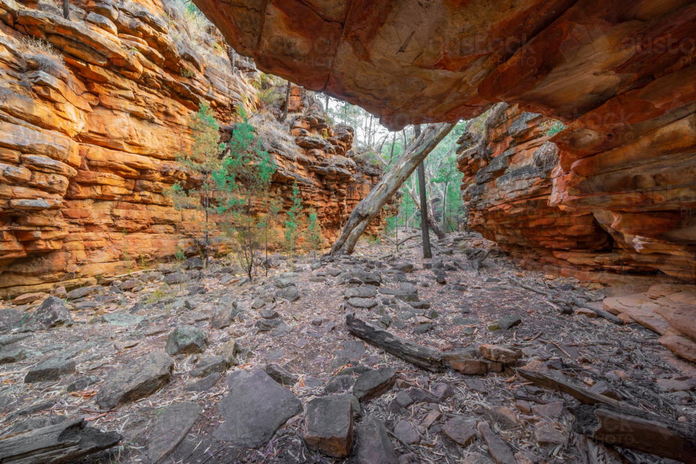 Image of Wide angle view of rock overhang at the base of a rocky gorge ...