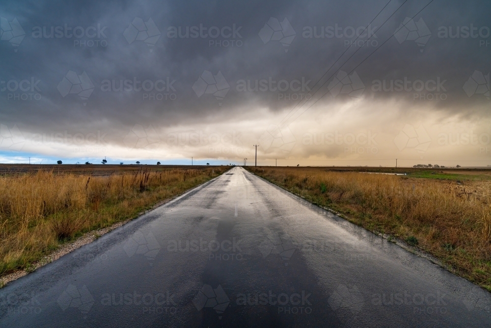 Image of Wide angled view down a country road with bright gap under ...
