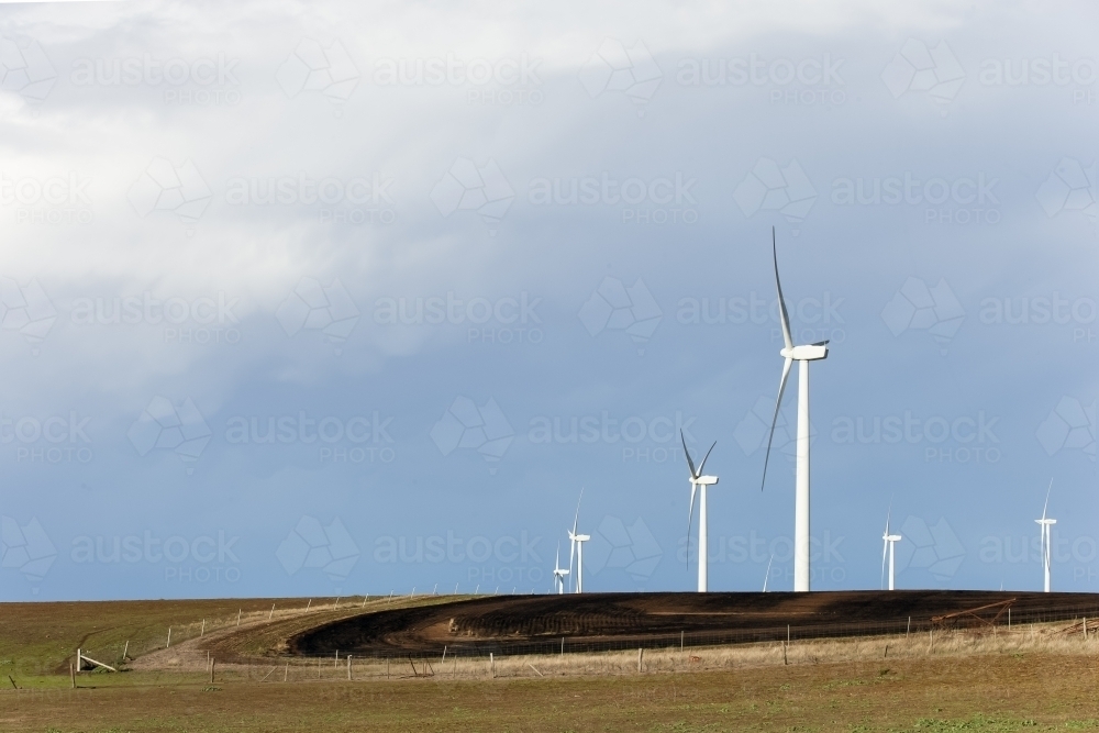 Image of Wind farm in cropped paddock - Austockphoto