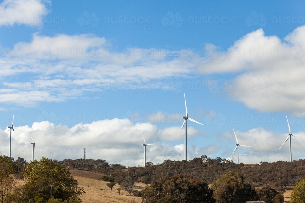 Image of Wind turbines on horizon along ridgeline above road in rural ...
