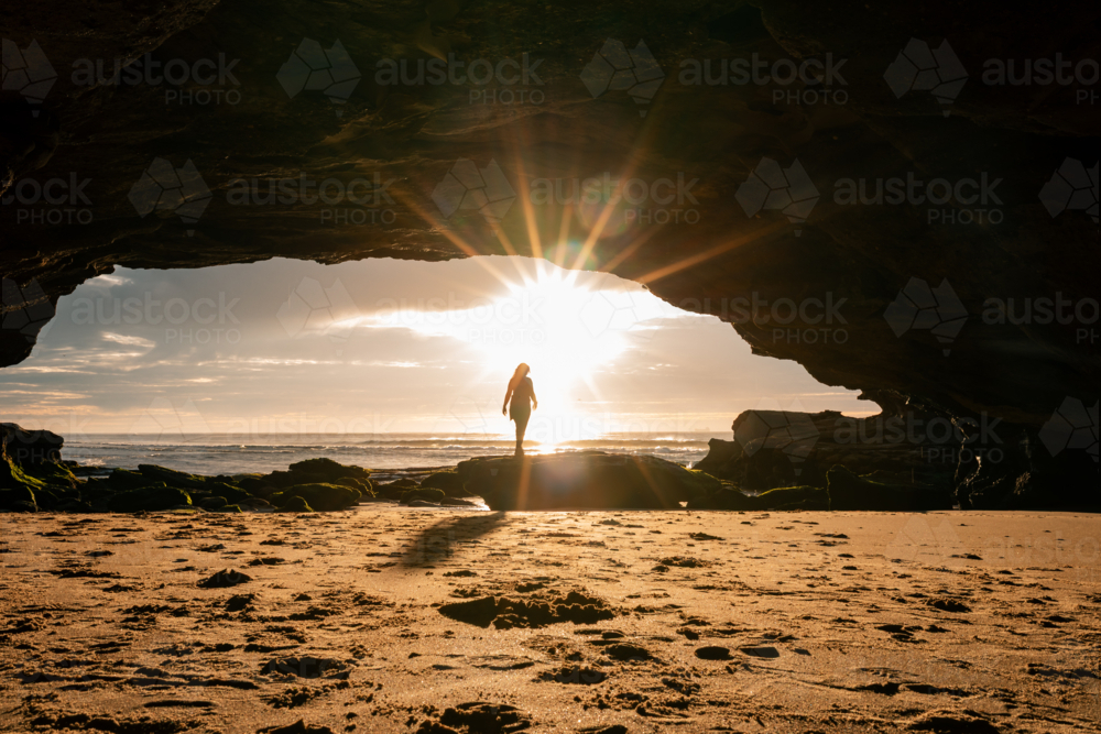 Image of Woman enjoying tranquil moment on the beach at sunrise ...