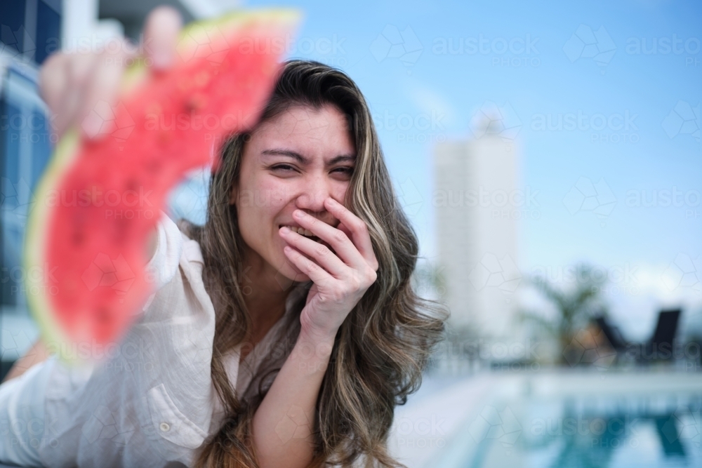 Image of Woman holding watermelon slice up to camera - Austockphoto