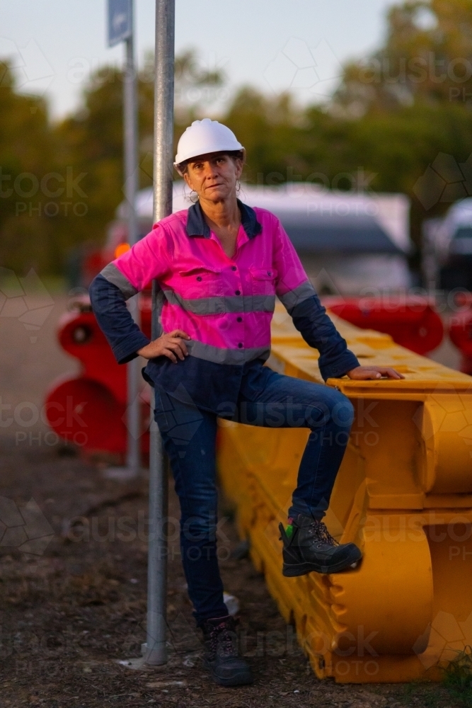 Image of woman in her forties wearing hi-vis and hard hat standing with ...