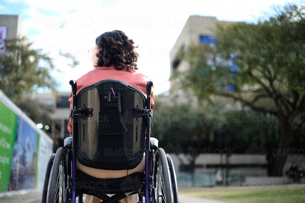 Image of Woman in modern wheelchair facing away - Austockphoto