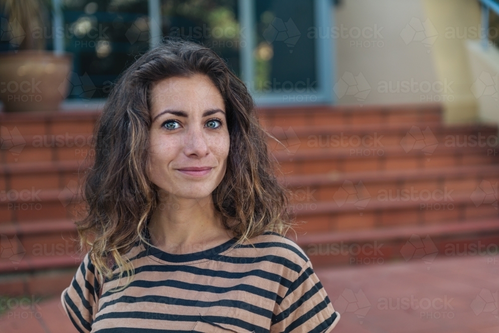 Image of woman leaving apartment building - Austockphoto
