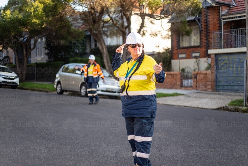 Image of Woman road worker with white helmet and yellow jacket standing ...