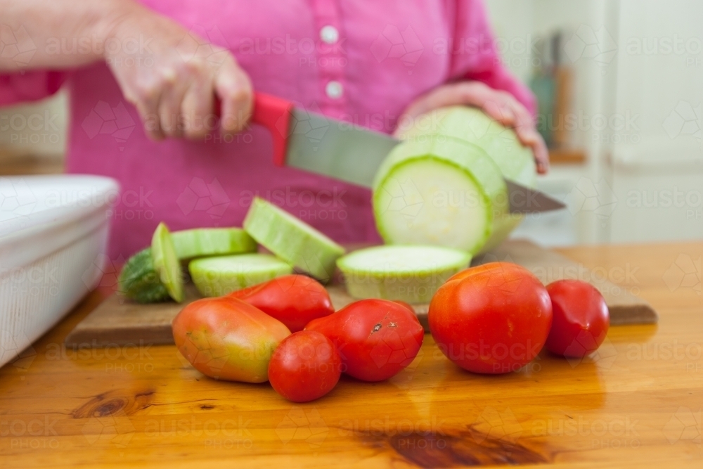 Image of Woman's hand cutting vegetables - Austockphoto