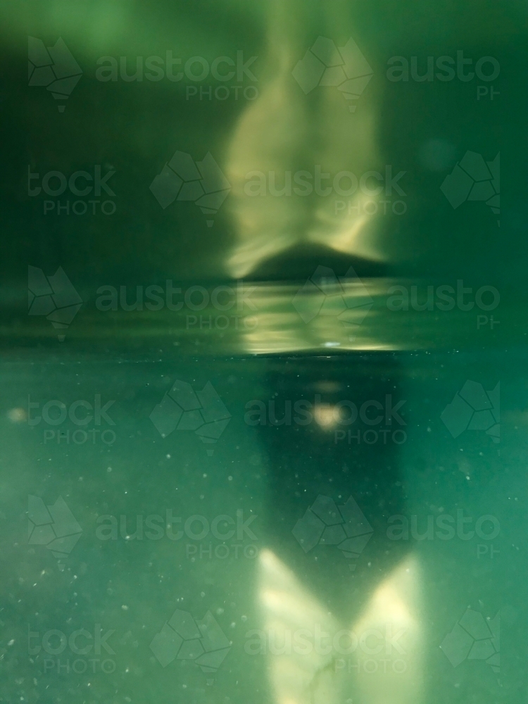 Image Of Womans Torso Submerged Under Ocean With Reflection In Black
