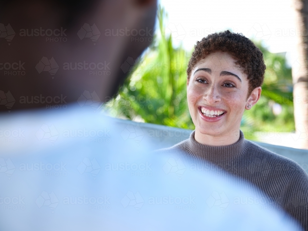 Image of Woman smiling during a conversation outside - Austockphoto