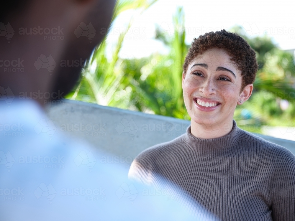 Image of Woman smiling during a conversation outside - Austockphoto