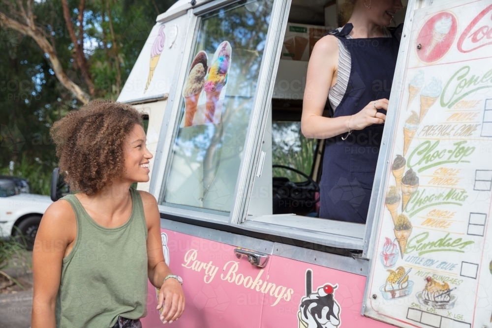 Image of Woman waiting to be served ice cream cone from an ice cream ...