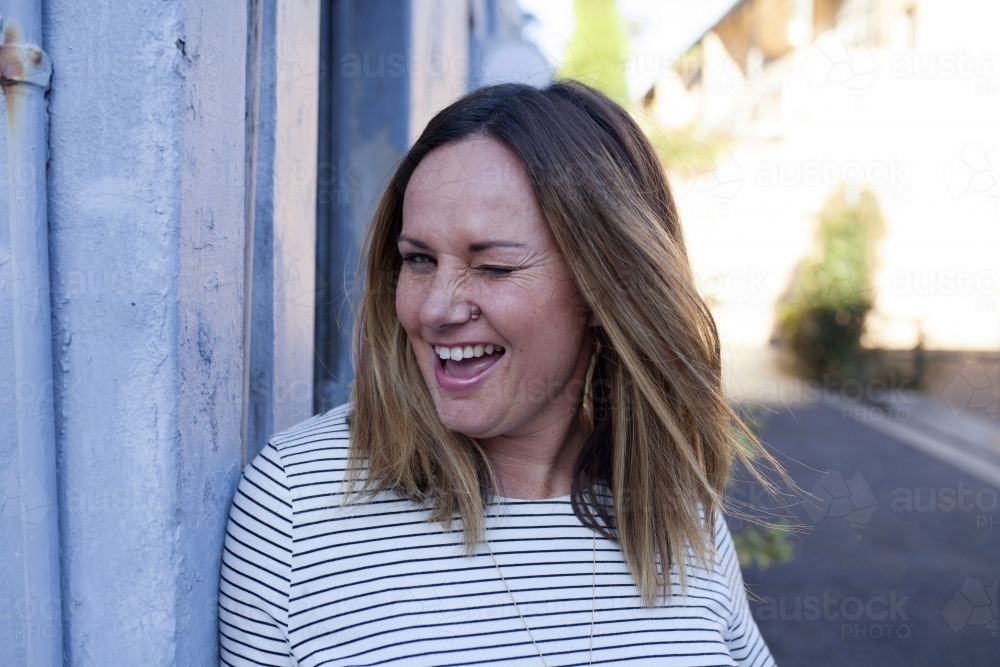 Image of Woman winking at the camera - Austockphoto