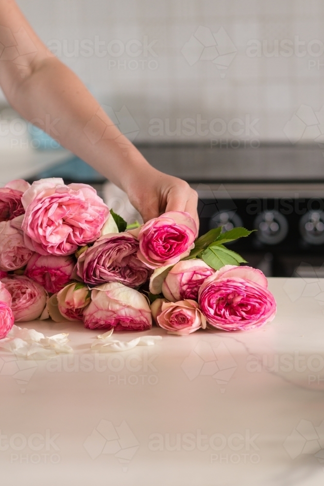 Image of woman with flowers in the kitchen - Austockphoto