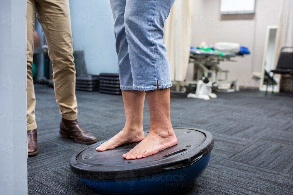 Image of Woman with lower leg injury balancing to strengthen joints ...