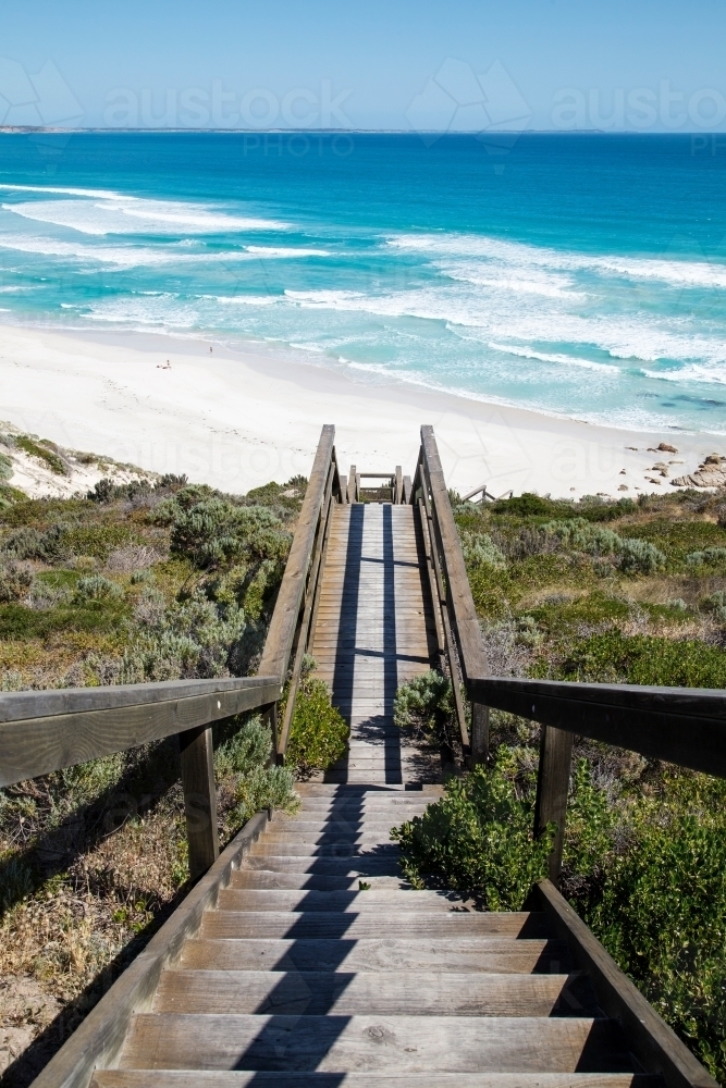 Image of Wooden steps leading down to white sandy beach - Austockphoto