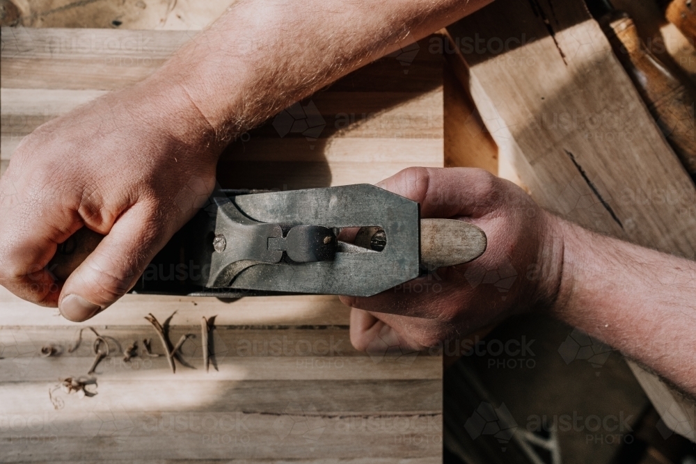 Image of Woodworkers hands at work on some timber. - Austockphoto