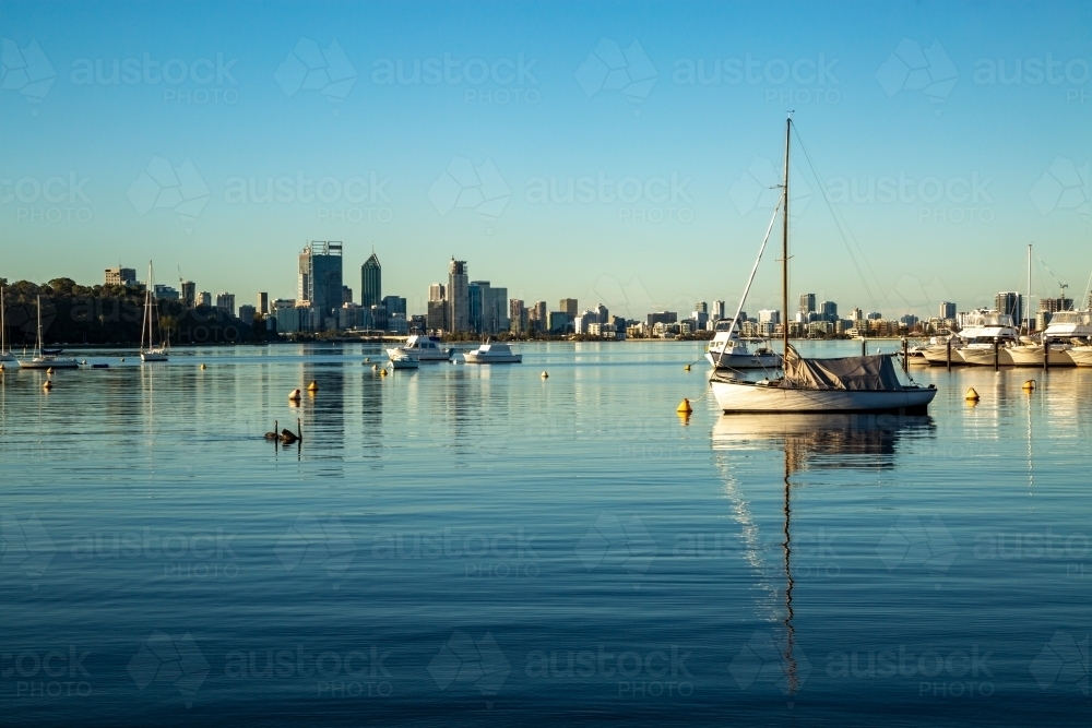 Image of Yacht reflection on calm water with downtown Perth in ...